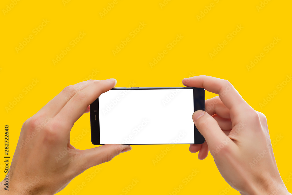 Closeup shot typing on mobile phone isolated on orange background ...