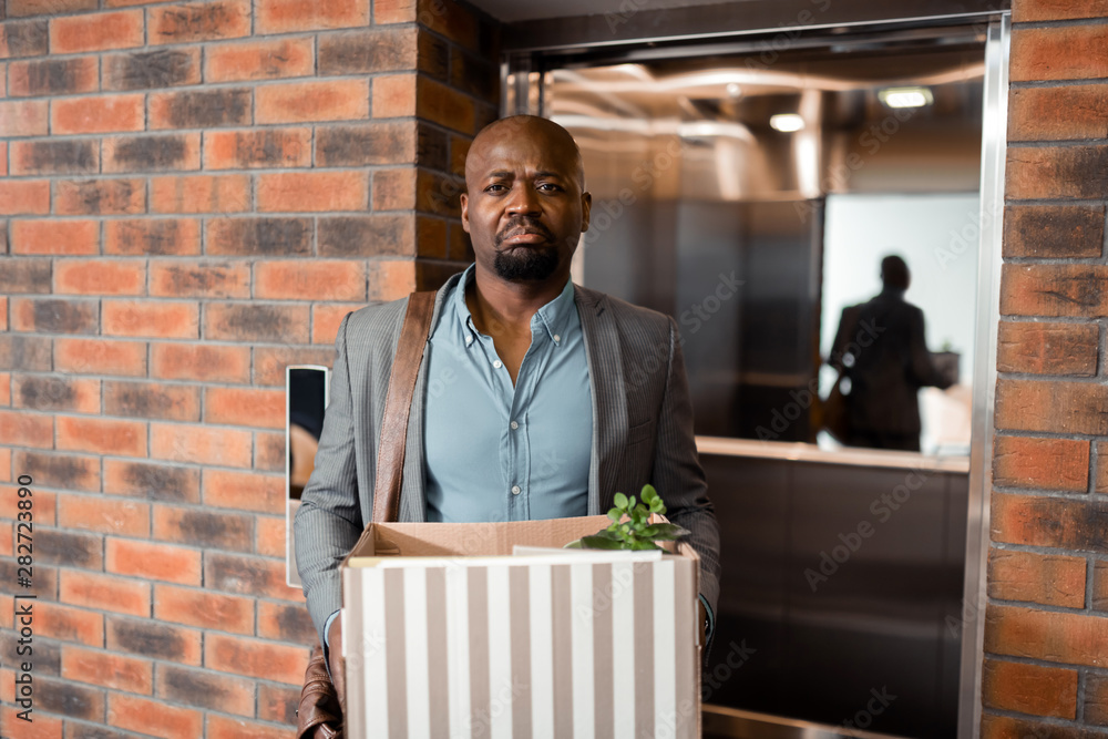 Dark-skinned office worker leaving the office after employee ...