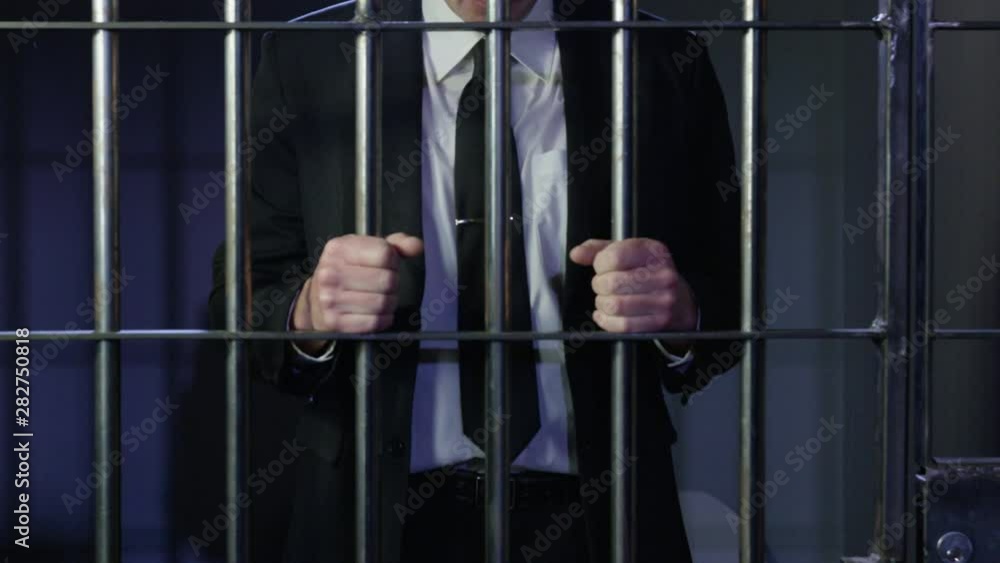 White collar criminal in jail behind bars Stock ビデオ | Adobe Stock