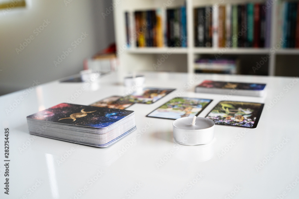 Close up on tarot card reading opening cards at home on the white table ...