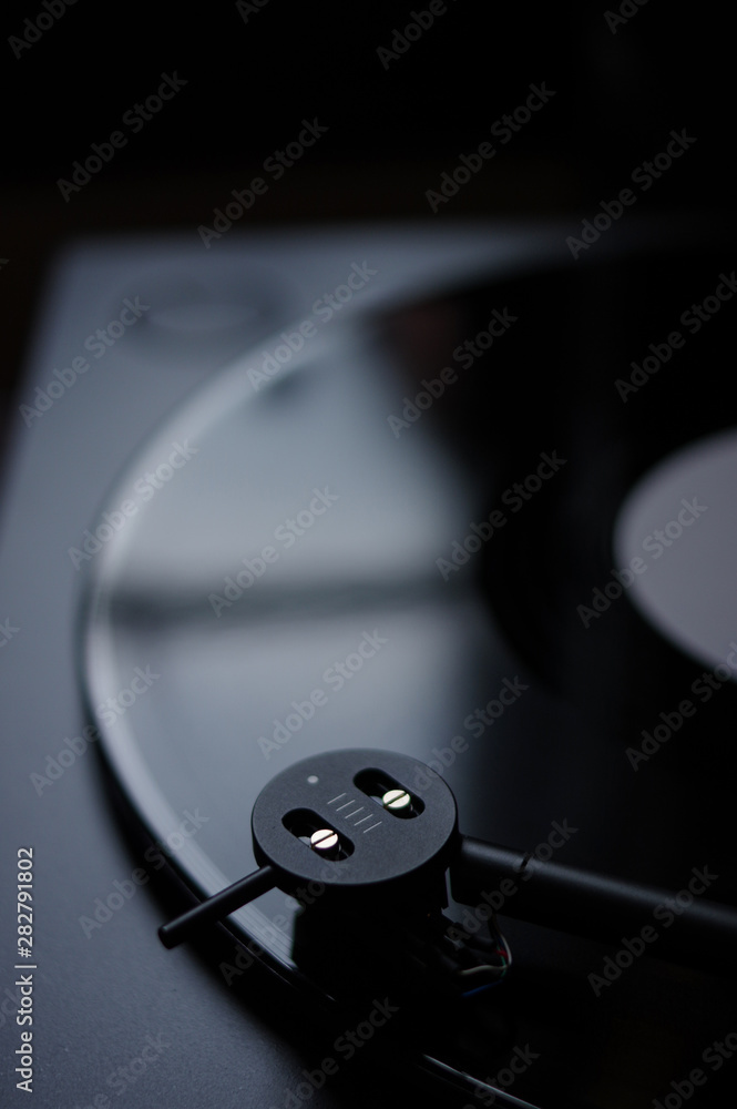 Modern round headshell with cartridge on straight tonearm and vinyl ...