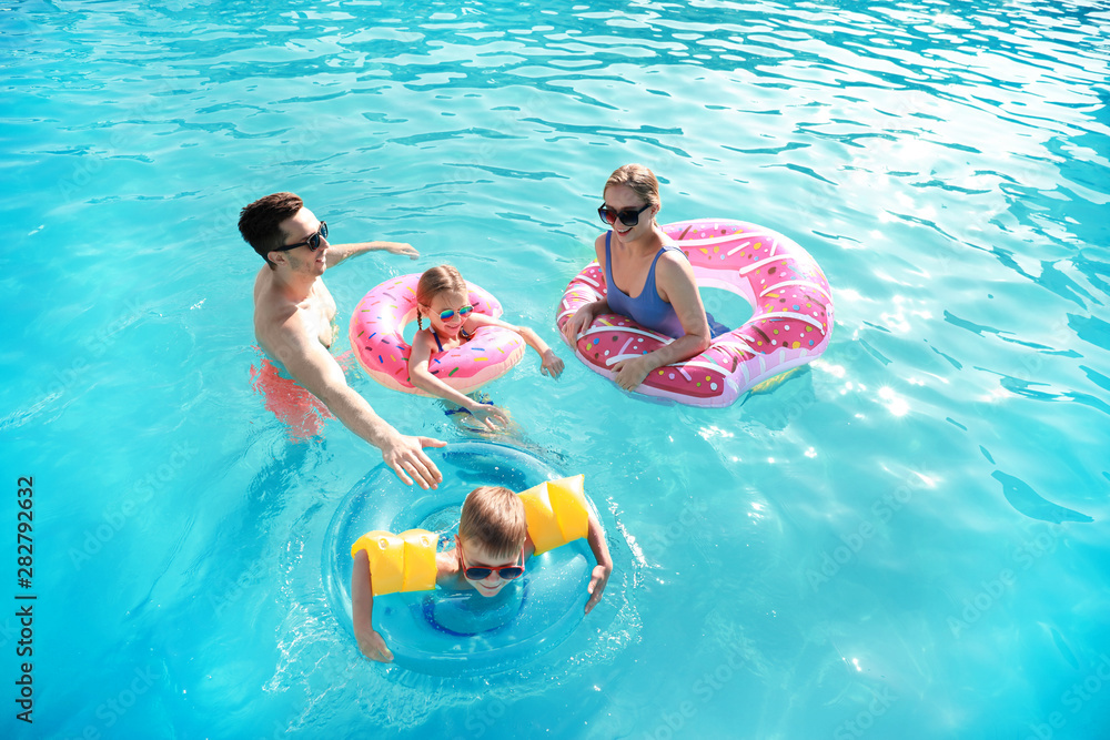 Happy family swimming in pool on summer day Stock Photo | Adobe Stock