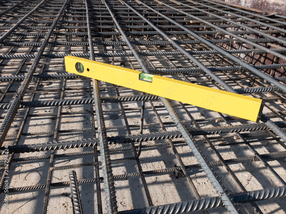 Building yellow colored level tool on the steel grid of residential ...