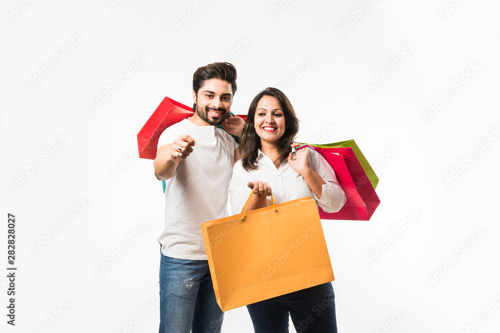Indian young couple shopping bags and blank debit/credit or electronic ...