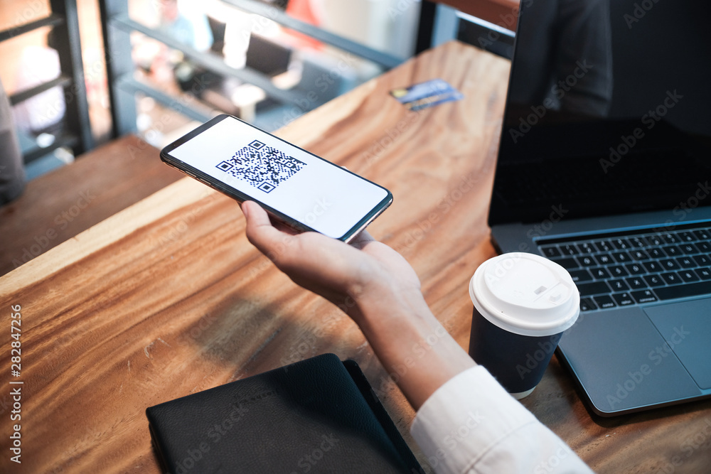Qr code payment. Woman scanning QR code online shopping cashless ...