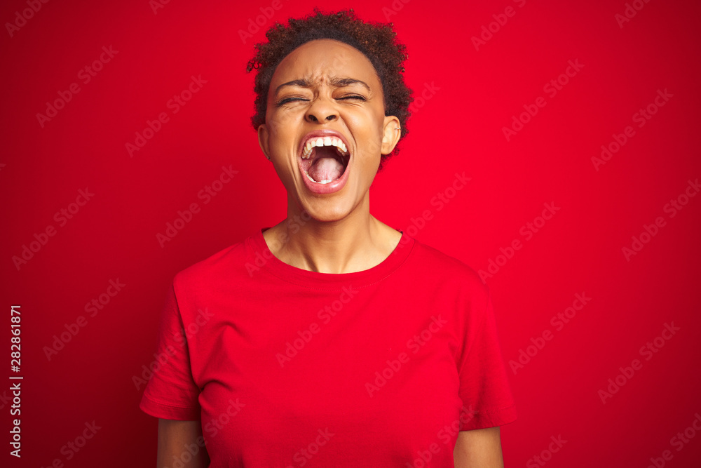 Young beautiful african american woman with afro hair over isolated red ...