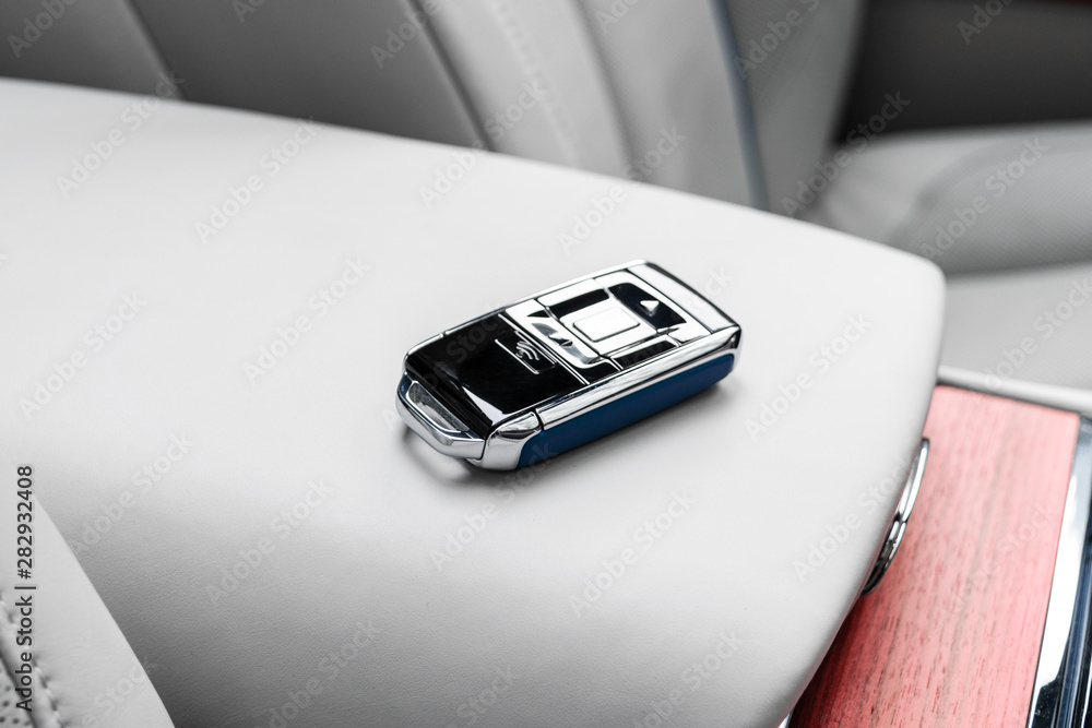 Closeup inside vehicle of wireless blue leather key ignition on white ...