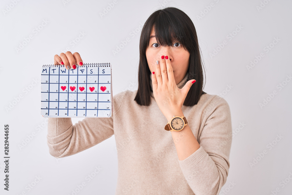 Young beautiful Chinese woman holding menstruation calendar over ...