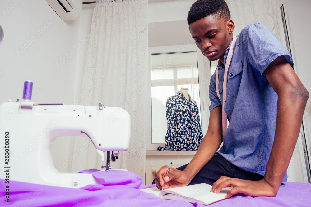 portrait of a handsome african man smiling seamstress with sewing ...