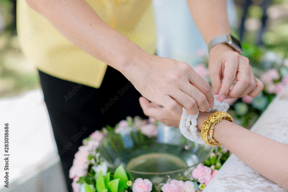 The bride's hand is tied with thread from the older culture in Thai ...