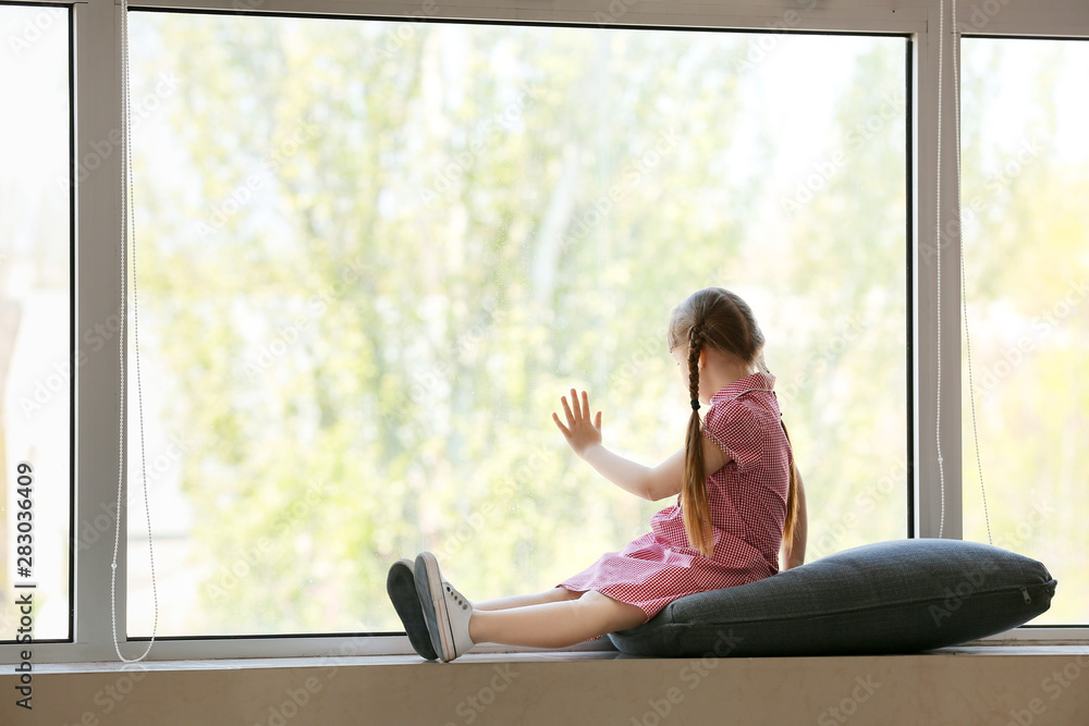 Little girl with autistic disorder sitting on window sill at home Stock ...