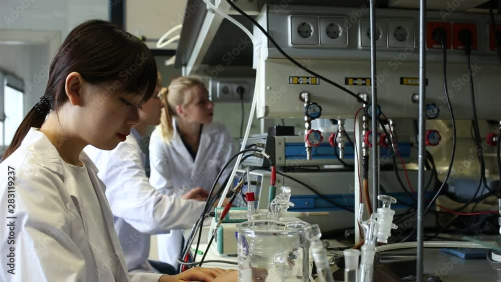 Intelligent Chinese girl working with reagent in test tube during ...