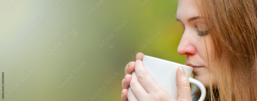 Banner. Girl with a red nose drinking hot tea from a white mug. Cold ...
