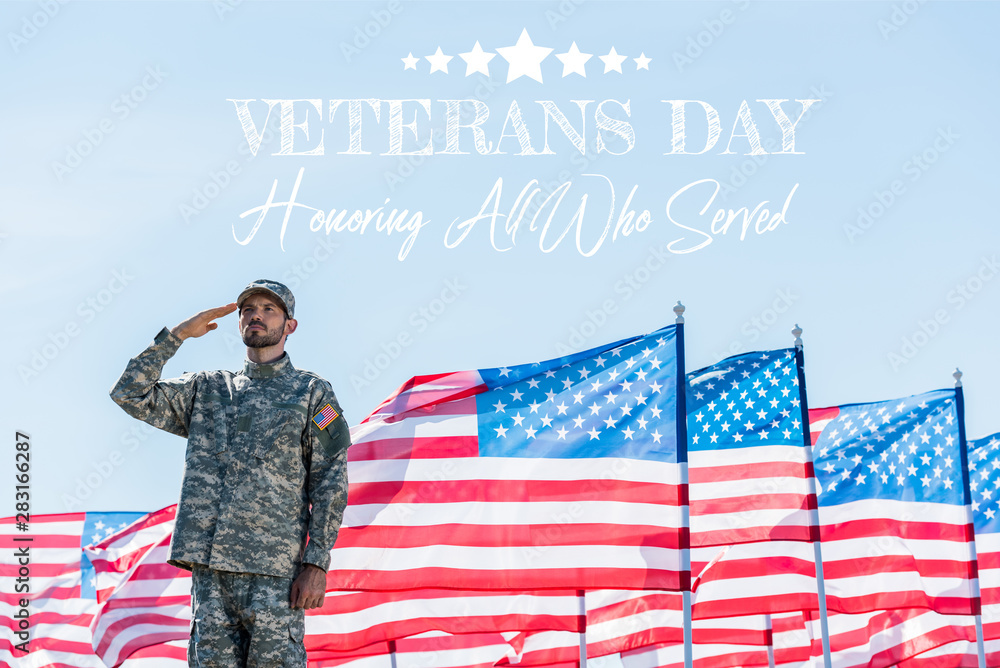 patriotic soldier in military uniform giving salute near american flags ...