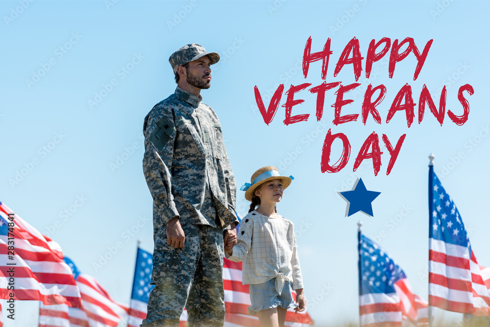 cute kid holding hands with military father near american flags with ...