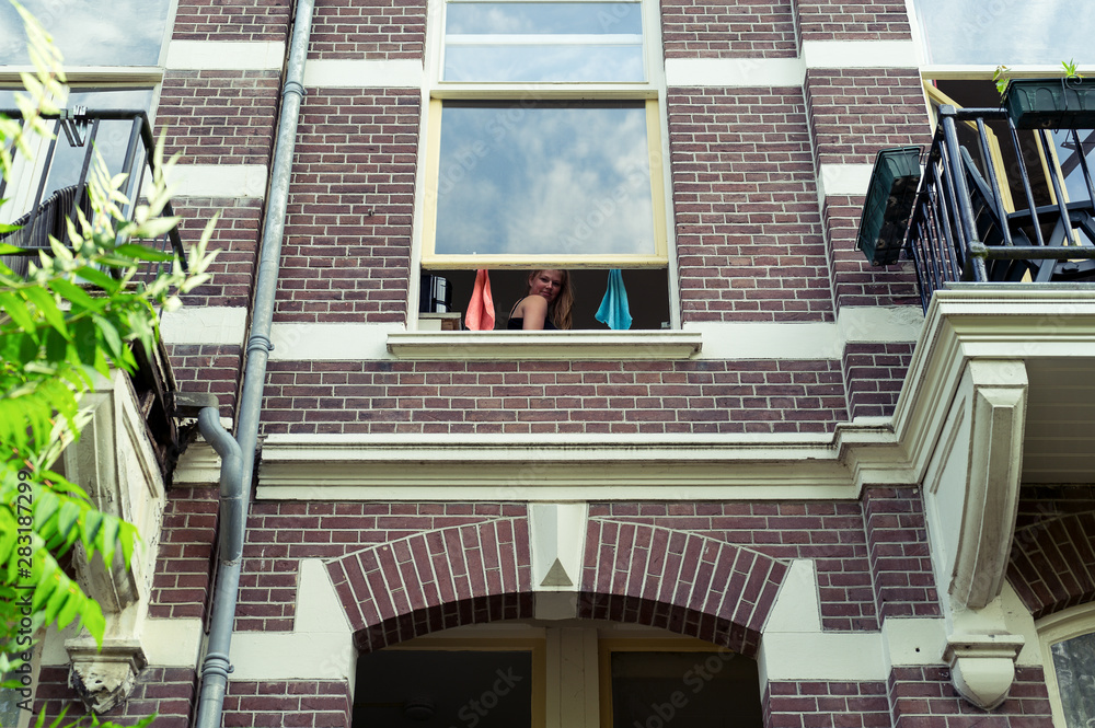 Dutch student girl standing in the kitchen and looking outside from the ...