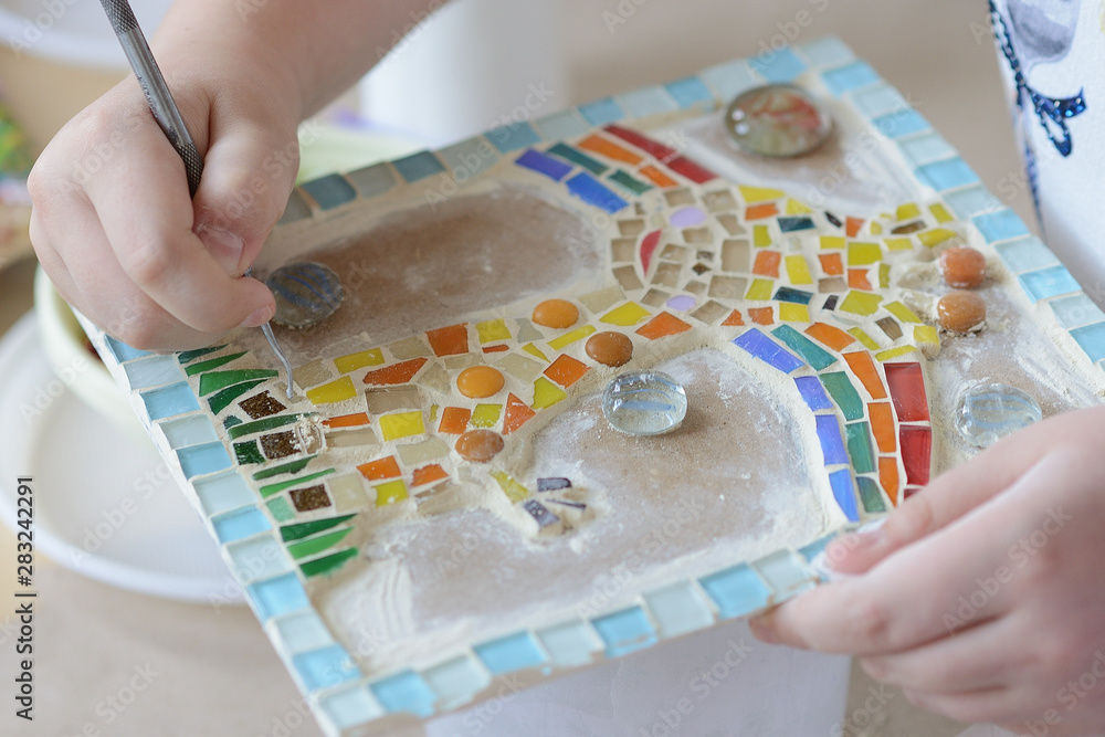 Process of making a mosaic picture from ceramic tile. The man organizes ...