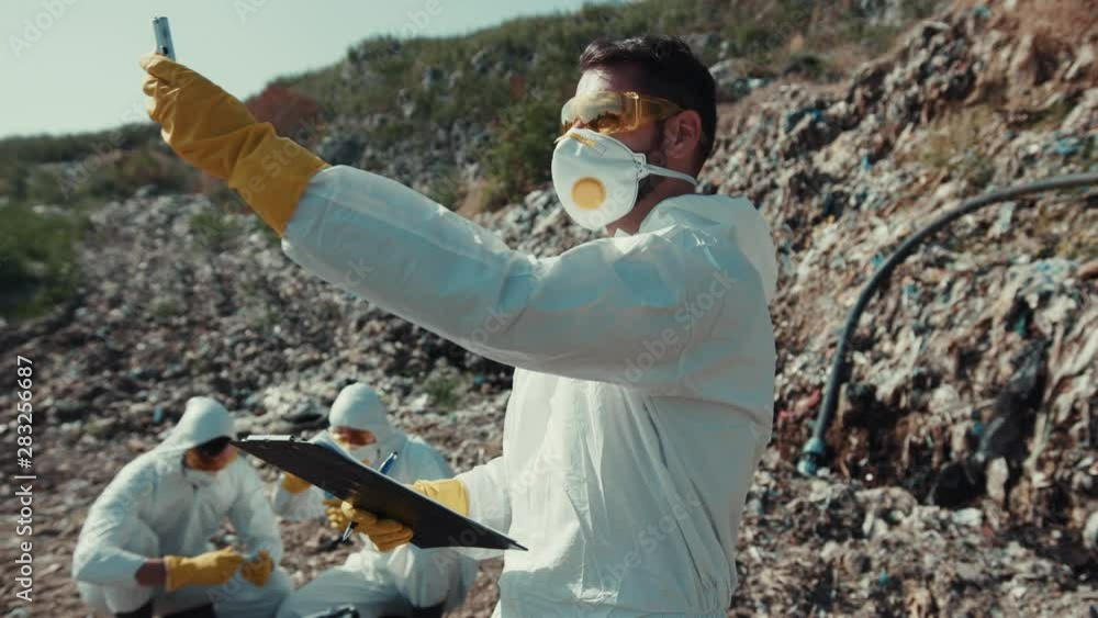 Recycling workers performing scientific research on landfill. Close-up ...