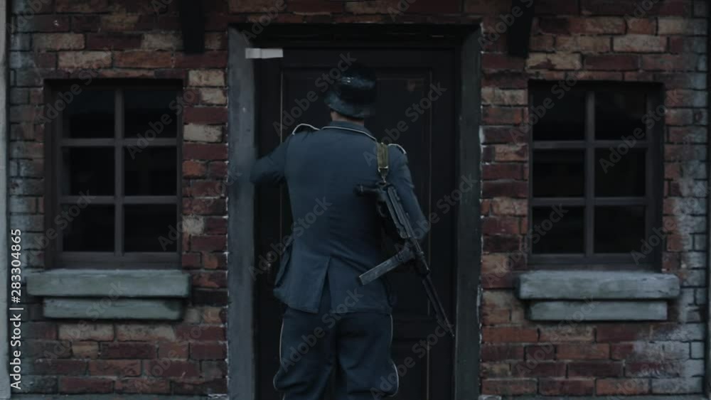 Vidéo Stock A rear close-up of a German soldier knocking at the door ...