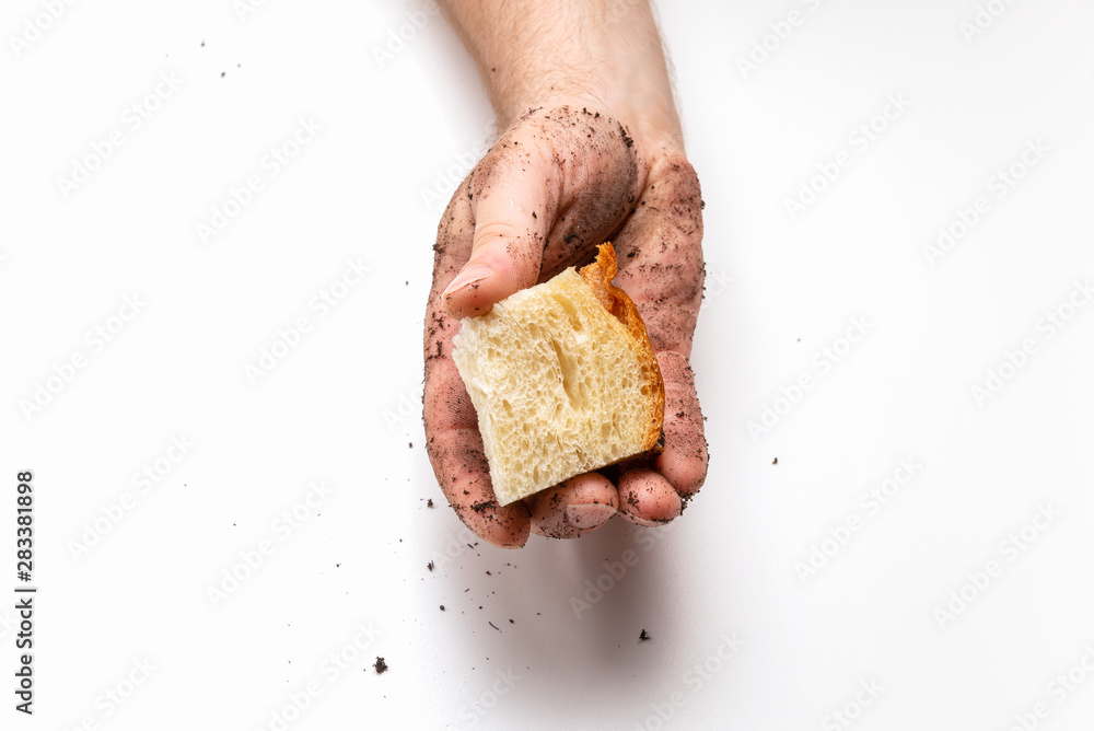 Male dirty hand is keeping one piece of white bread. International Day ...