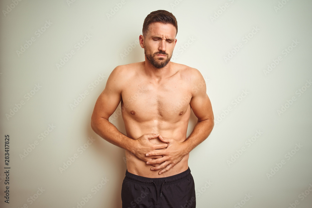 Young handsome shirtless man over isolated background with hand on ...