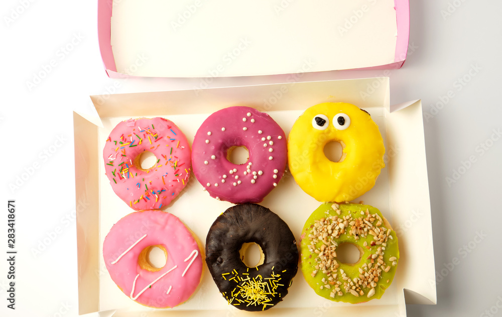 six round different donuts with sprinkles in a paper white box Stock ...