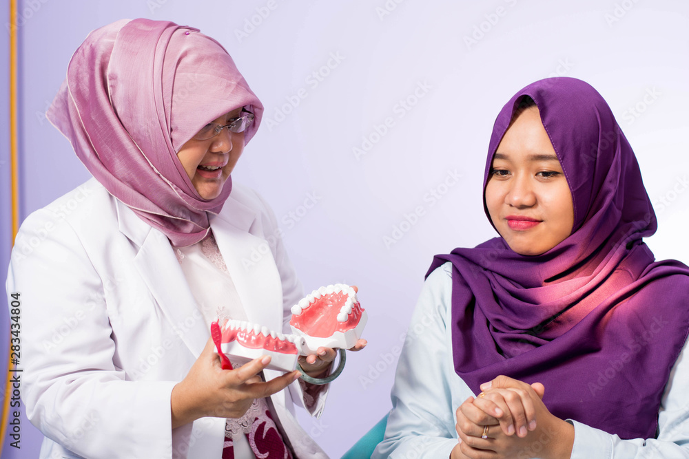 female muslim hijab dentist explained how to brush teeth corectly with ...