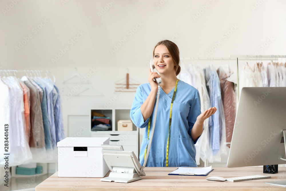 Worker of modern dry-cleaner's talking by phone at reception Stock ...