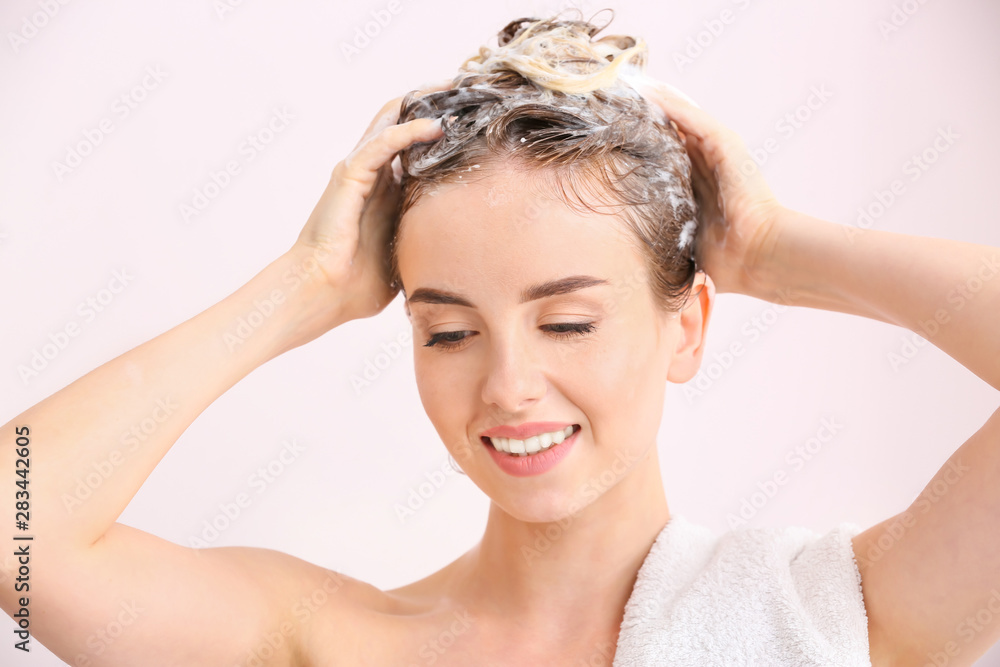 Beautiful young woman washing hair against light color background Stock ...