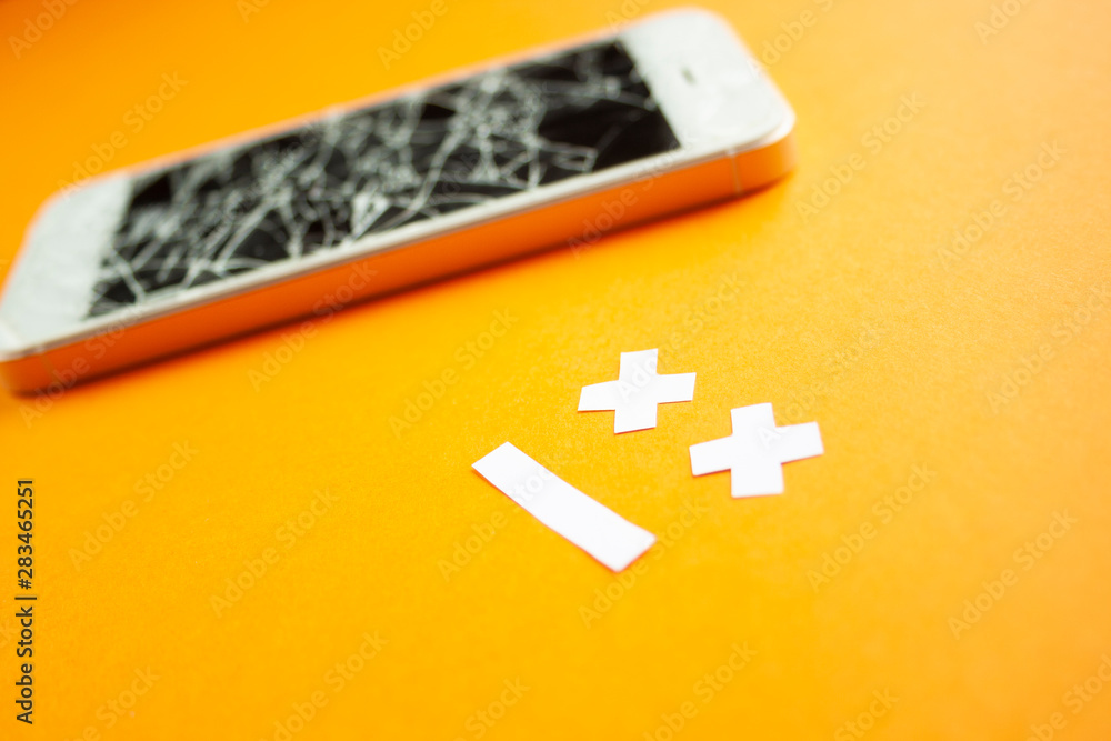 Broken smartphone with cracked destroyed screen on orange background ...