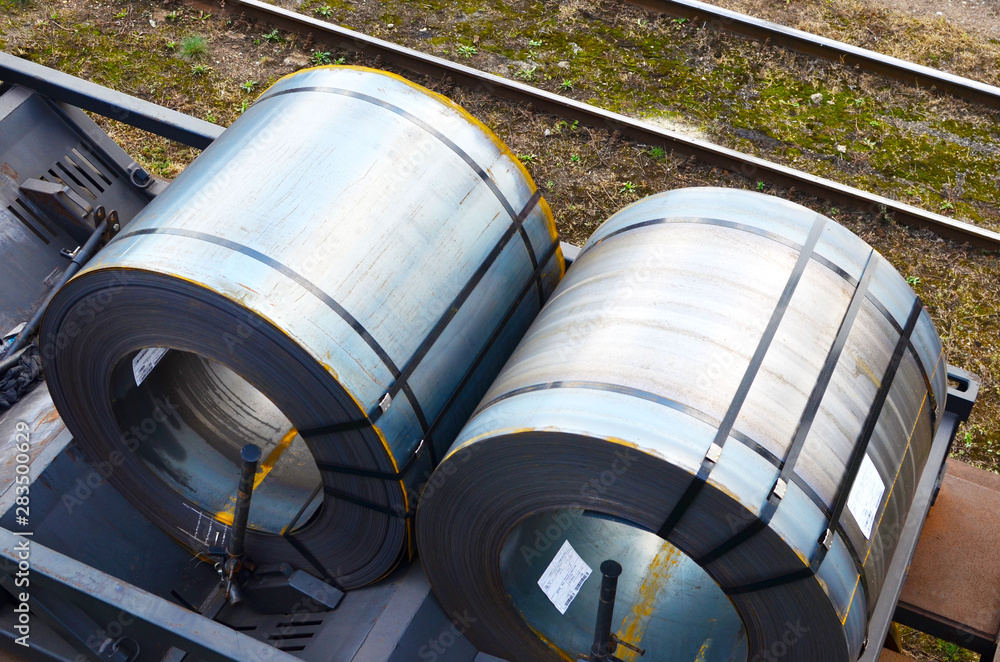 Rolled steel coil on on a freight train fixed by a chain. Import/export ...