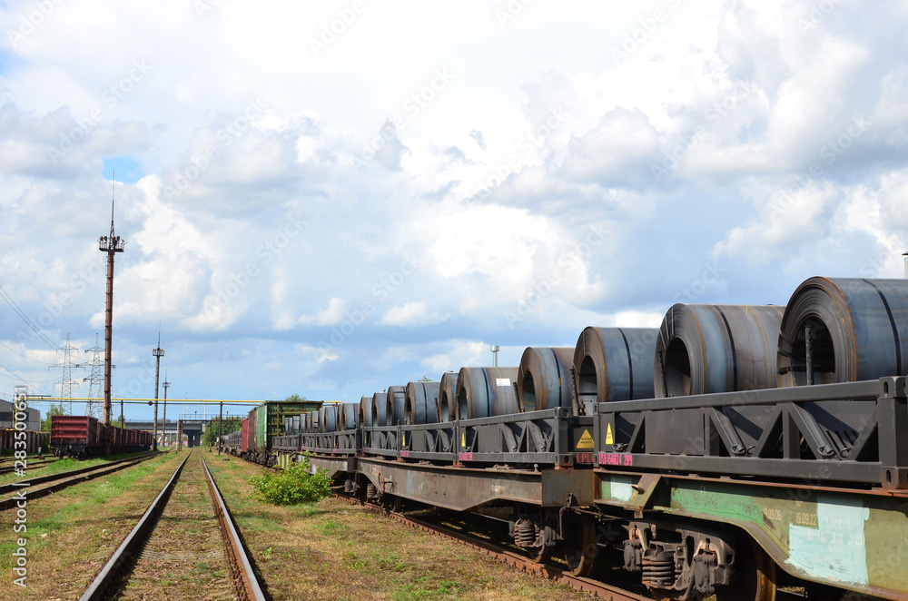 Rolled steel coil on on a freight train fixed by a chain. Import/export ...