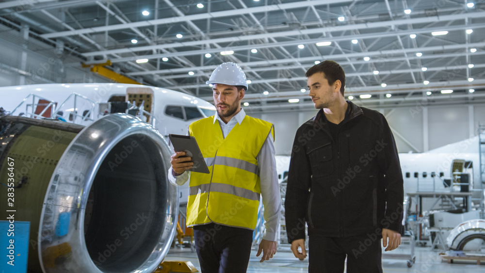 Team of Aircraft Maintenance Mechanics Moving through Hangar. Holding ...