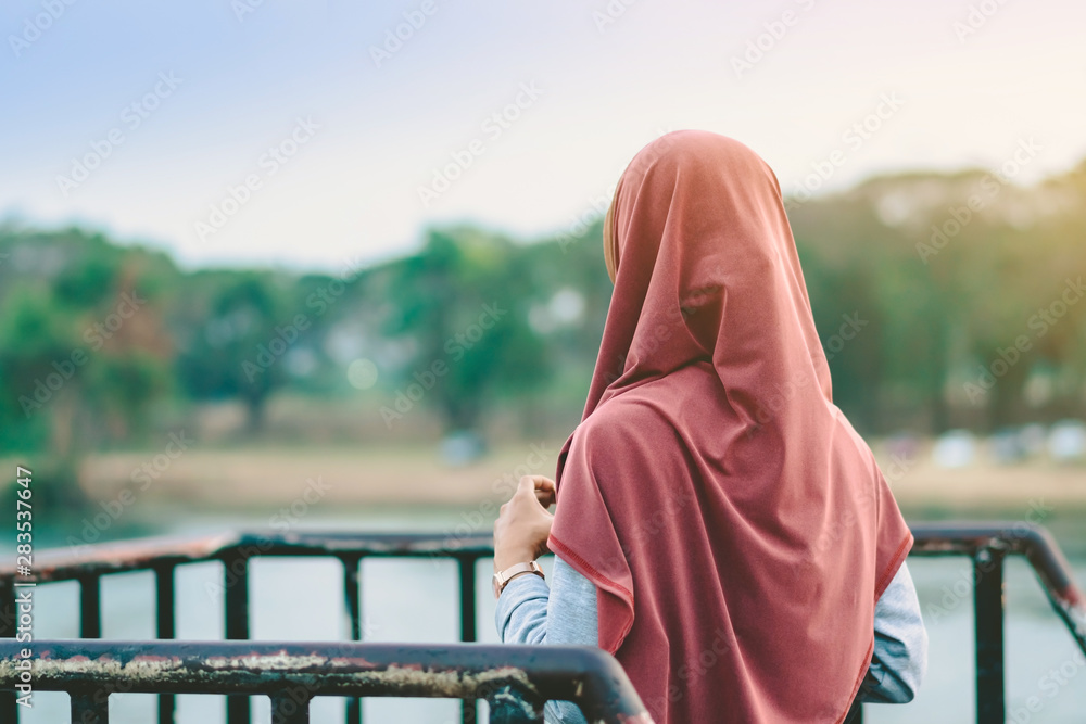 Back view of Muslim woman relax and admire the beautiful scenery in the ...