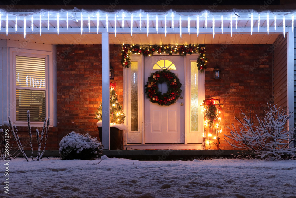 Beautiful winter blizzard night. House main entrance and porch ...