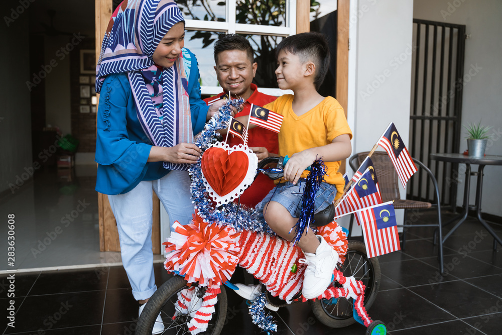 happy malaysian family decorate bicycle with flag for independence day ...