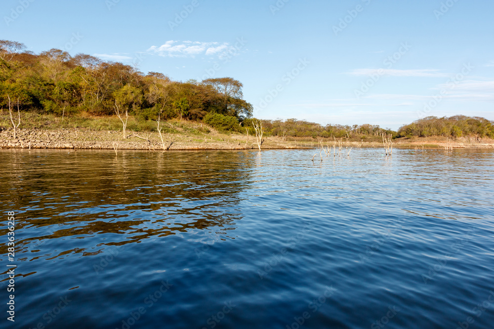 Wooded shoreline of the massive reservoir named Lake El Salto in ...