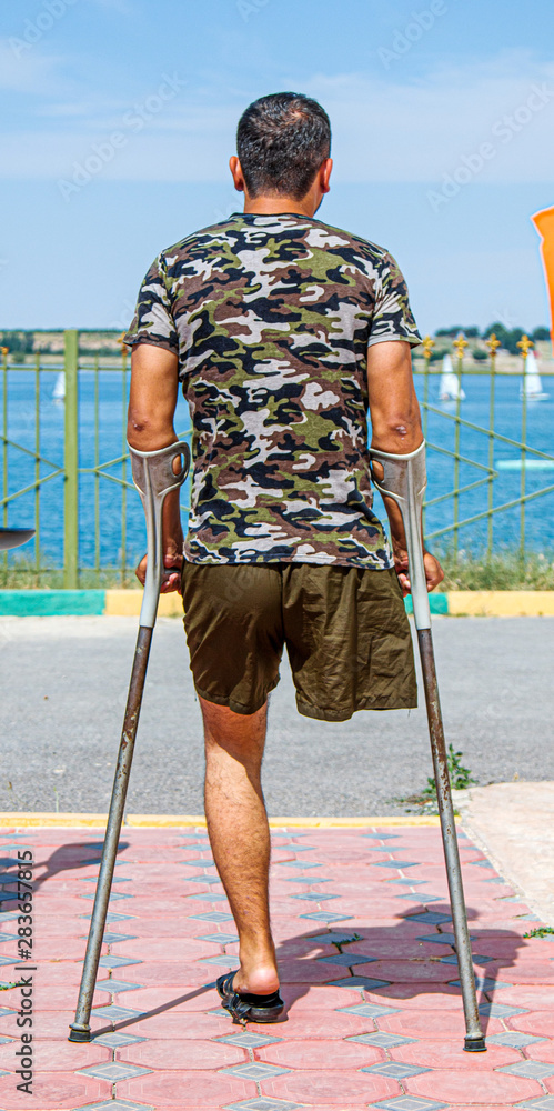 Man with an amputated leg on crutches in nature in the city Stock Photo ...