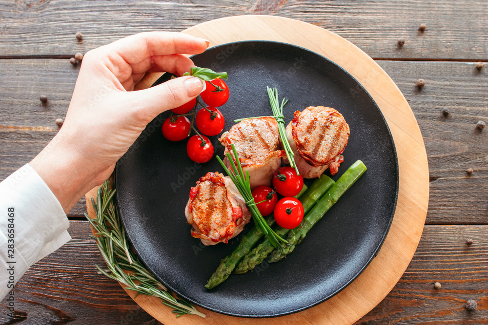 Restaurant food presentation. Chef decorating a pork dish. Grilled ...