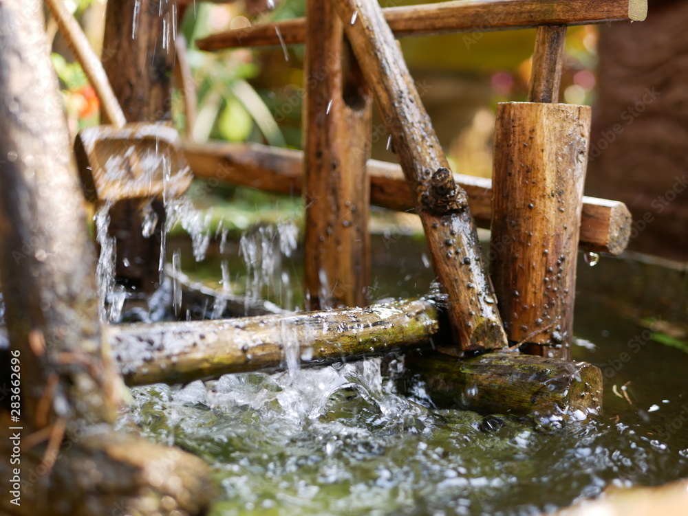 Selective focus of water drops falling from a bamboo hydraulic turbine ...