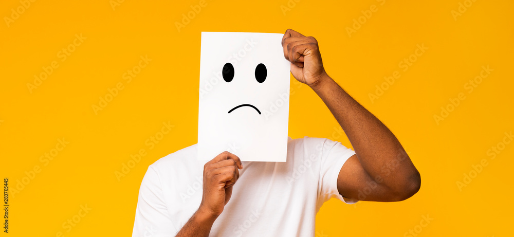 Black man holding paper with sad face Stock Photo | Adobe Stock