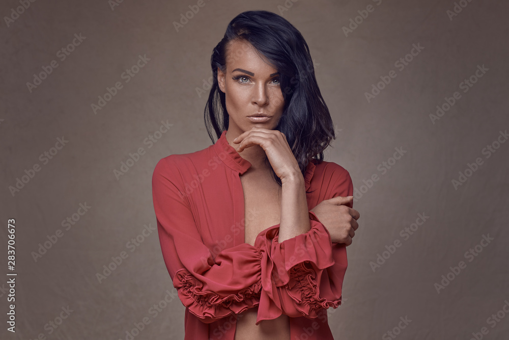 Sexy woman with unbuttoned red shirt covering her breasts and giving ...