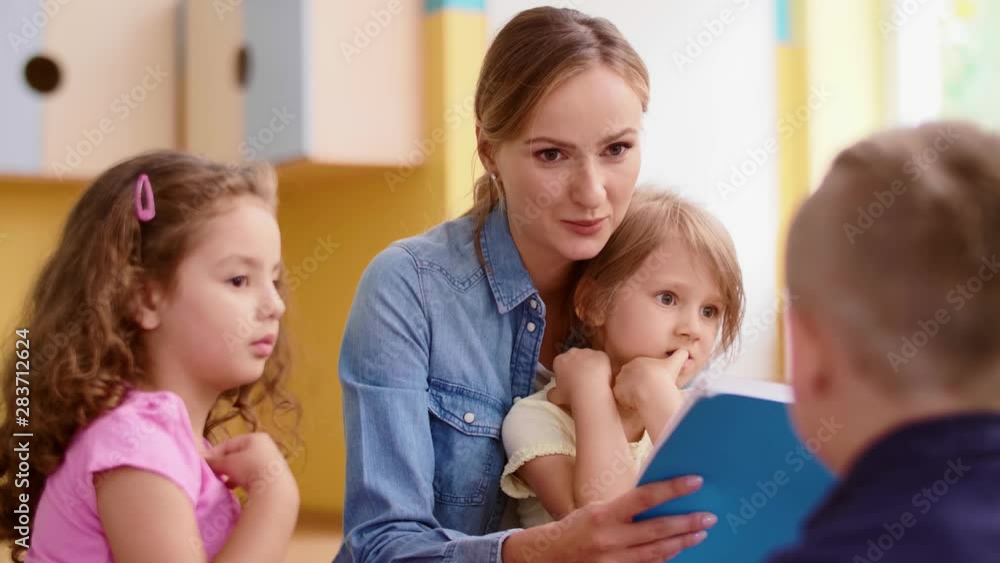 Kids and teacher reading a book together in the preschool Stock Video ...