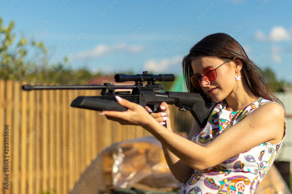 Pretty hunter girl aiming with hunting rifle in the outer wood. Carbine ...