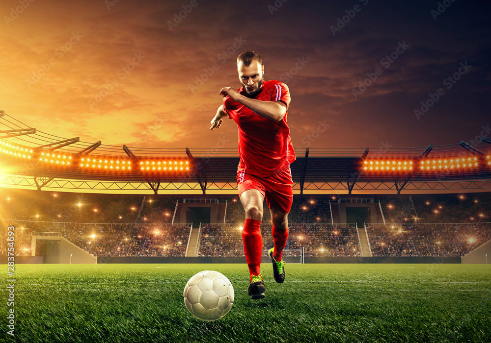 Soccer player in action with a ball on a stadium Stock Photo | Adobe Stock