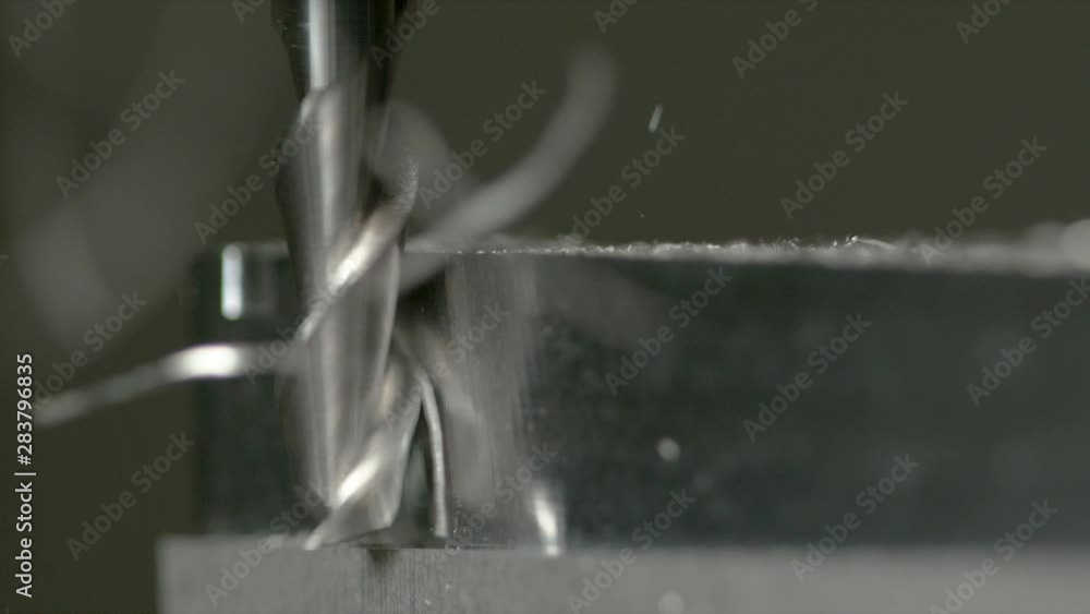 SLOW MOTION, MACRO, DOF: Thin pieces of excess metal fly off a piece of ...