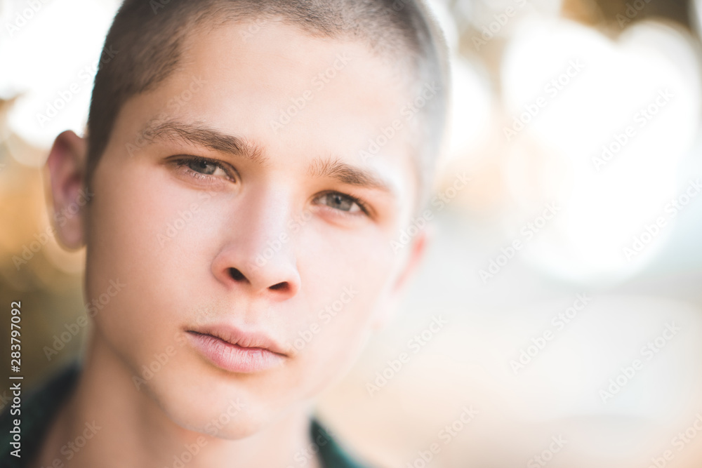 Handsome boy 18-20 year old posing over nature background closeup ...