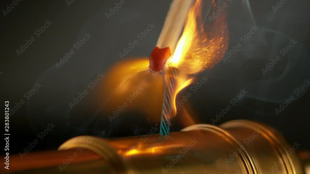 SLOW MOTION, MACRO, DOF: Burning match lights up the short blue fuse of ...
