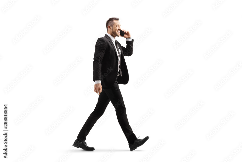 Businessman walking and talking on a mobile phone Stock Photo | Adobe Stock