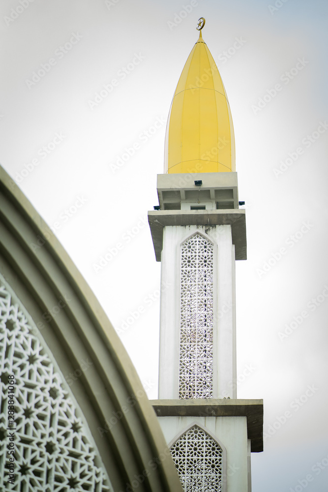 Foto de A tall white and yellow minaret of a Muslim mosque against the ...